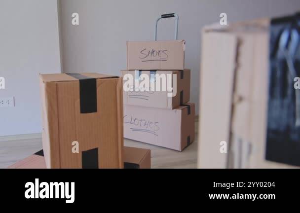 A stack of boxes with the words books and clothes written on them. The boxes are piled on top of ...