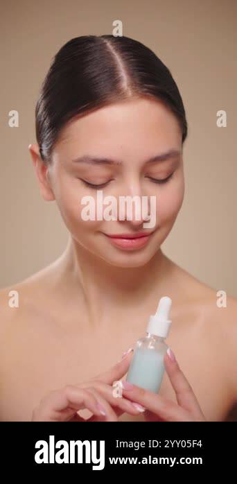 Beautiful young woman holding a cosmetic jar of oil serum or hyaluronic ...