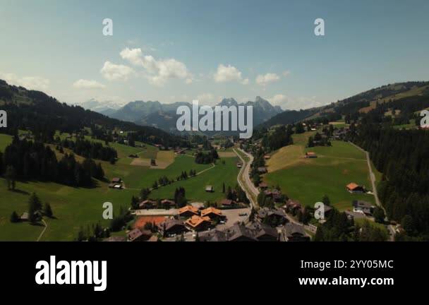 Drone view of traditional Swiss alpine village surrounded by mountains ...