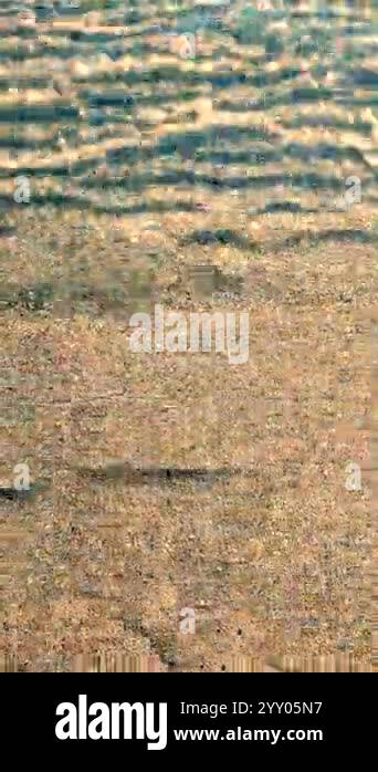 Small waves of clean transparent water rolling onto sand of shore on ...
