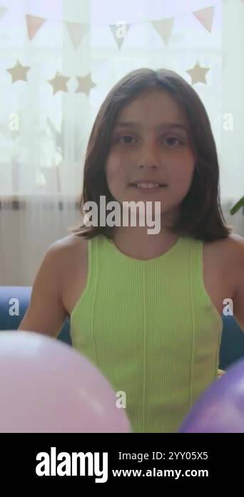 Vertical Portrait Of Gen Alpha Girl Throwing Up Two Balloons And Smiling At Camera While Having