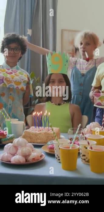 Vertical portrait of company of diverse gen alpha friends looking at ...