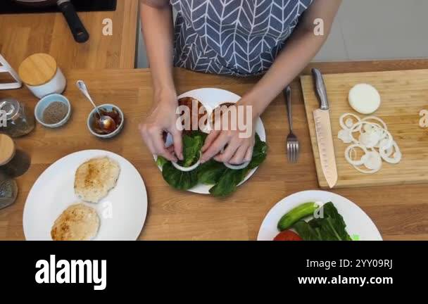 A skilled chef cooking grilled chicken burgers at the modern kitchen ...