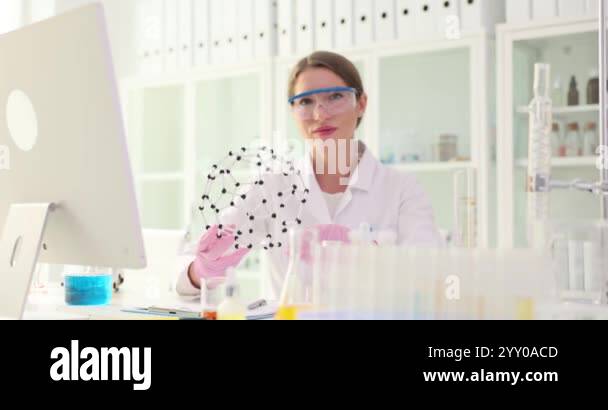 Woman researcher explains components of molecular model. Scientist ...