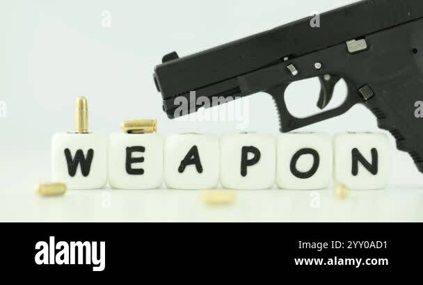 Black handgun and shiny bullets positioned on surface of table ...