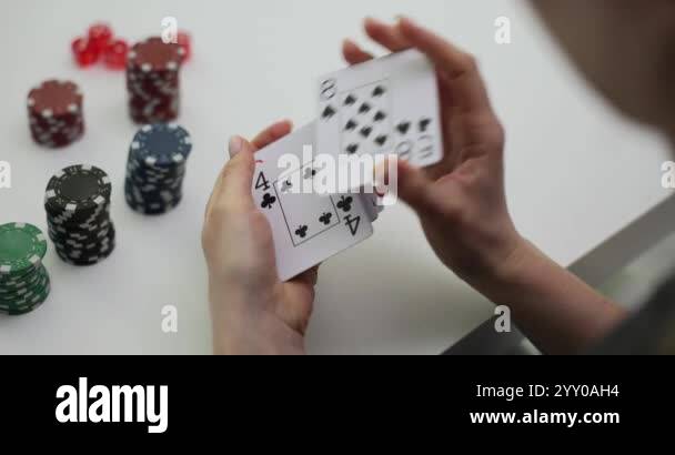 Female croupier shuffles deck of playing cards before dealing poker ...