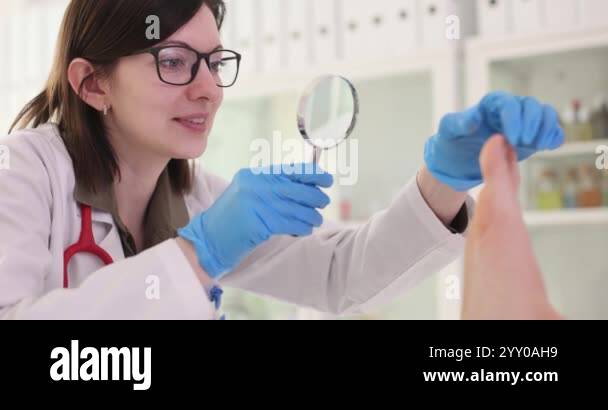 Positive woman doctor examines fungus on patient foot skin with ...