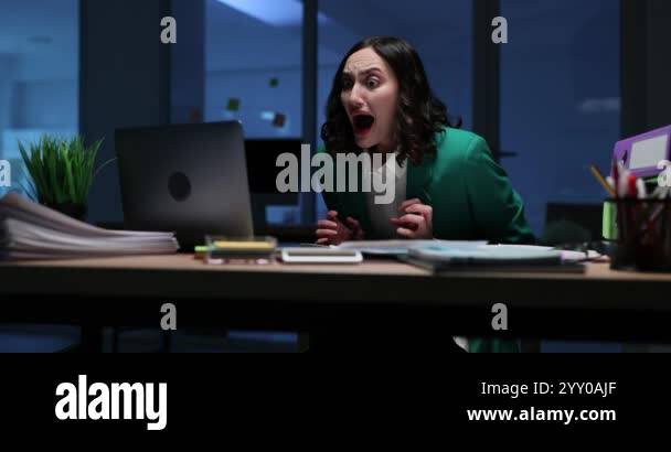 Exhausted woman employee looks at computer screen in office late at ...