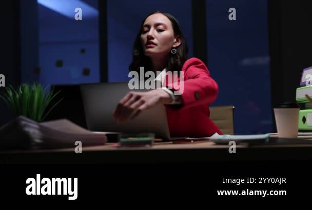 Unhappy woman manager checks commercial report at desk in empty night ...