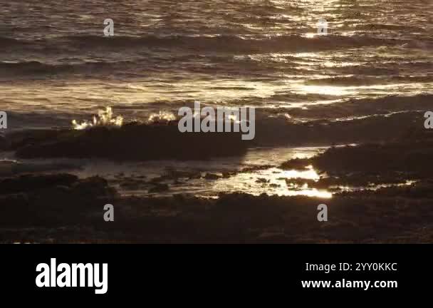 Zoomed in footage of a big sun setting on the horizon, tropical beach ...