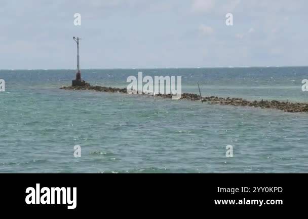 Narrow strip of rocks and corals with a pole at sea Stock Video Footage ...