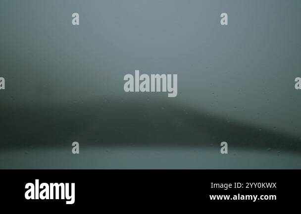 Poor visibility through windshield of car driving along country road on ...