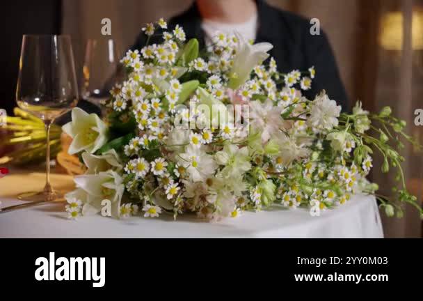 Festive flowers bouquet and romantic couple in love at restaurant table ...