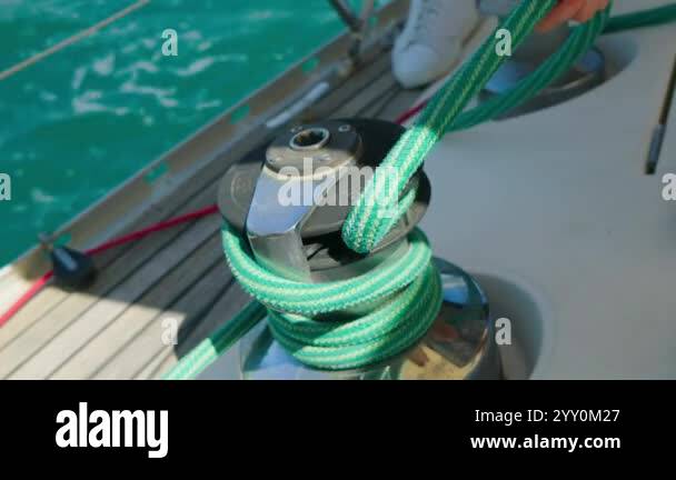 Professional sailor weakens rope on cleat of sailboat. Experienced ...