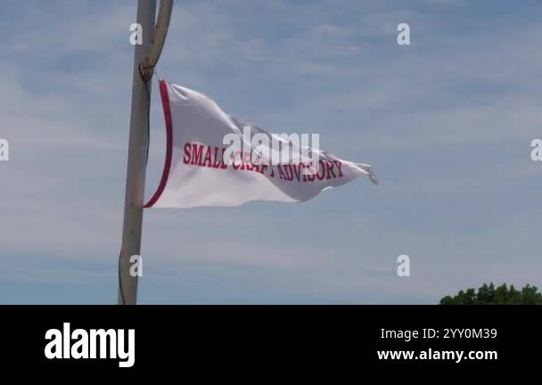 White flag with Small Craft Advisory tied to a post and waving in the ...