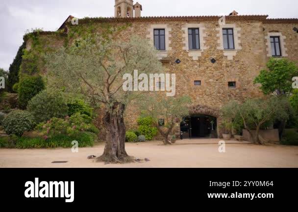 Castell d Emporda hotel with garden and historical arch gate ready to meet guests. Medieval ...