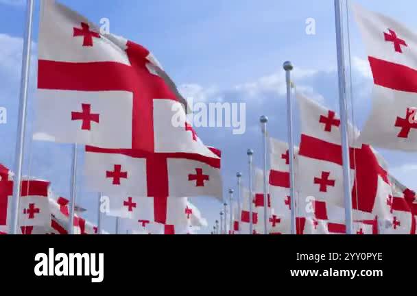 The national flags of Georgia, fluttering in the wind against the blue ...