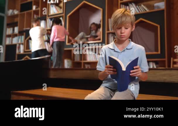 Attractive caucasian boy reading a book while group of smart students ...