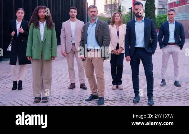 Seven diverse business professionals stand together in a modern office ...