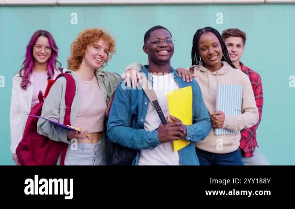 group of happy, diverse students pose together in front of a colorful ...