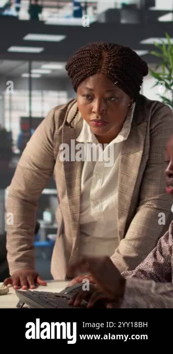 Vertical Video Female employee and manager gathered around a ...