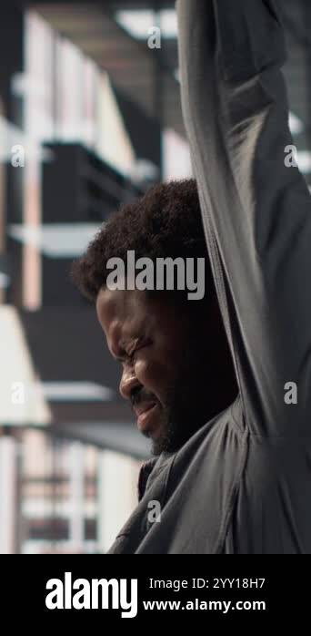 Vertical Video Black male CEO dealing with back pain and stretching his ...