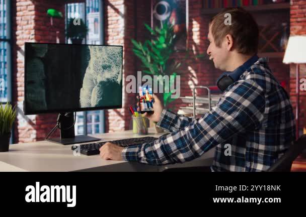 Man in workspace watching videos on social media on smartphone. Person ...