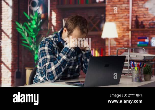 Tired man in living room home office shrugging head, upset after having ...