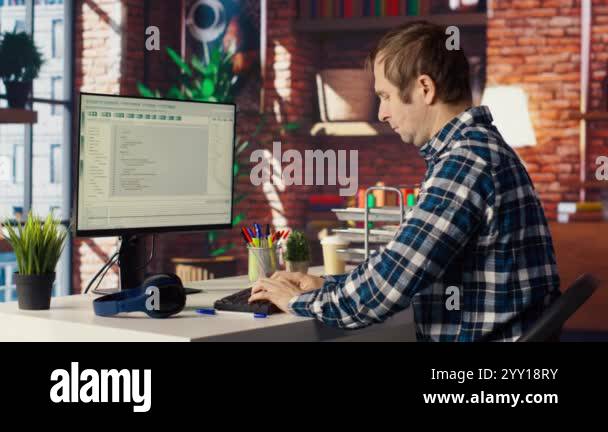 Man In Home Office Stretches Back While Looking At Ui On Pc Screen Feeling Fatigued While