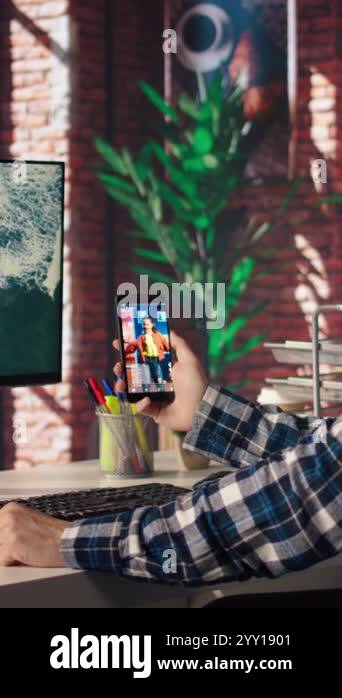 Man in workspace watching videos on social media on smartphone. Person ...