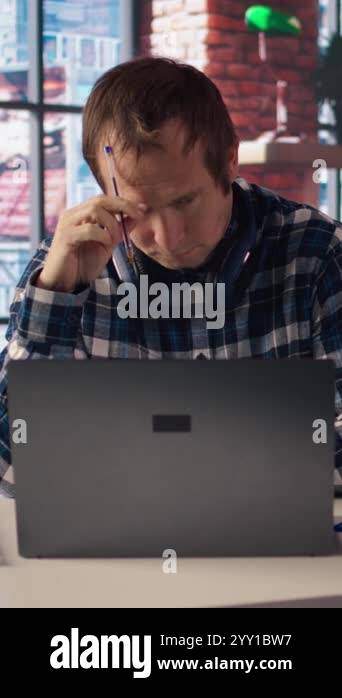 Stressed man in home office scratching head with pen, upset after ...