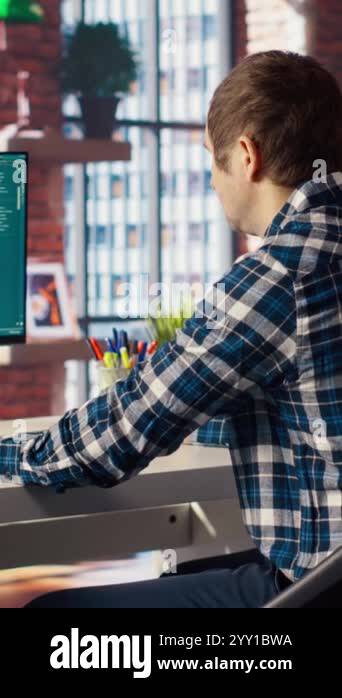 Man seated at desk using AI LLM chatbot software in modern urban home ...