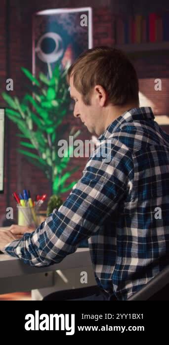 Man In Home Office Stretches Back While Looking At Ui On Pc Screen Feeling Fatigued While