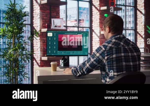 Man in apartment workspace using AI software turning text prompt into photos. Person in brick ...