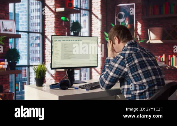 Software developer at computer waiting for code to finish compiling ...