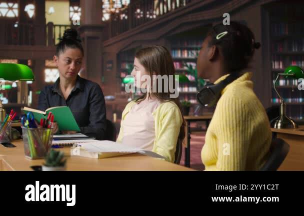 Elementary students receiving support from a tutor working on homework ...