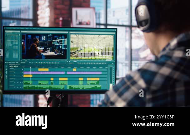 Video editor wearing headphones to polish raw footage and improve audio ...