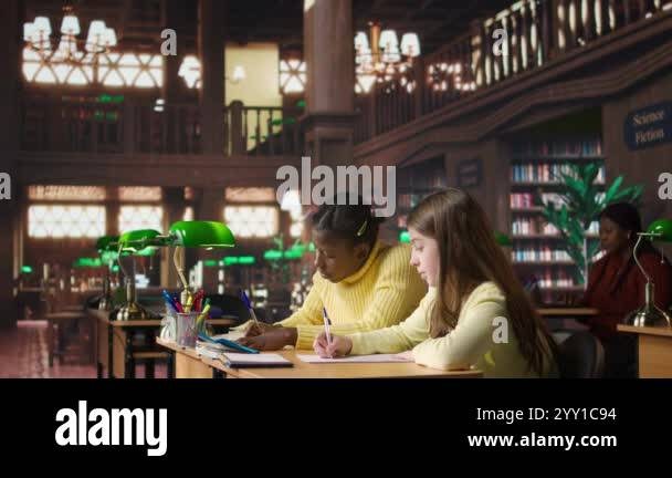 Diverse scholars helping each other finish the homework at the library ...