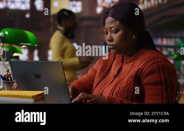 African american positive librarian working in a peaceful public ...