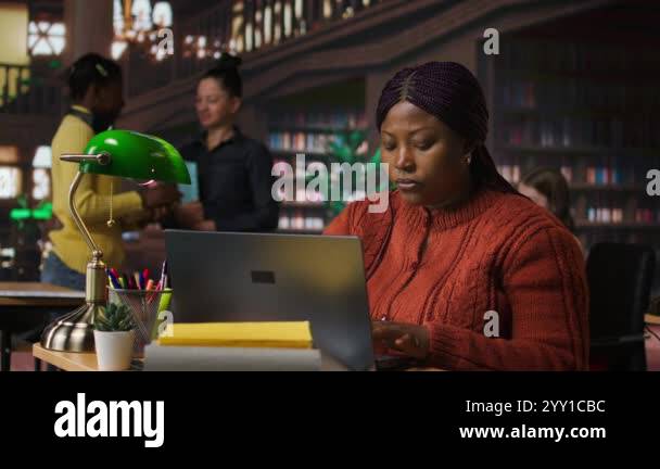 African american positive librarian working in a peaceful public ...