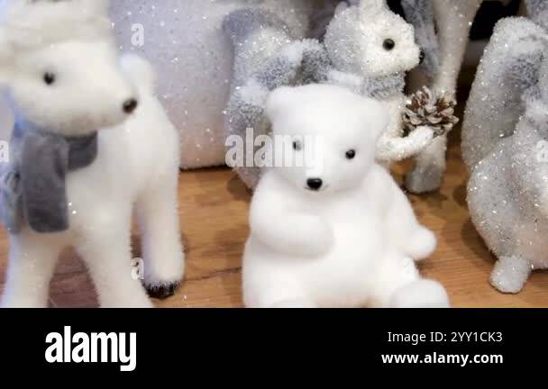 A festive display of holiday plush toys, featuring a small bear figure ...
