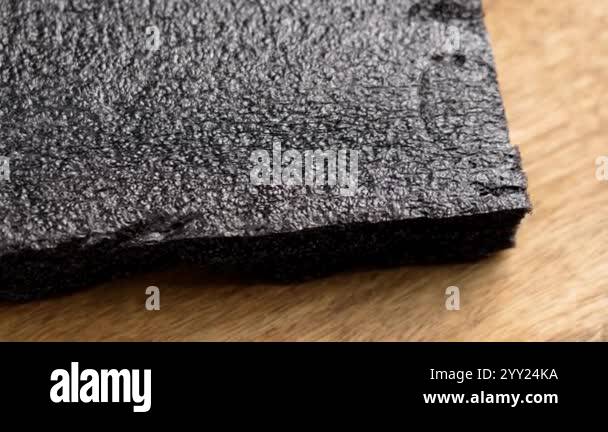 Black porous packaging foam with textured surface for secure shipping ...
