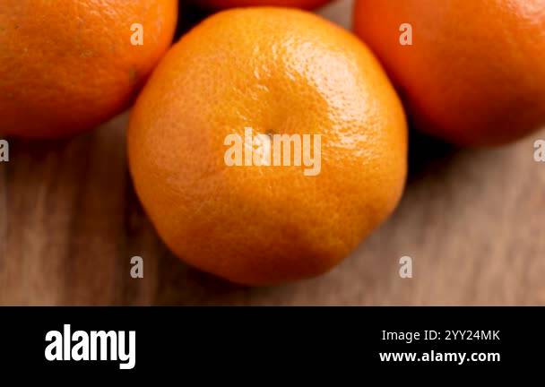 Ripe organic tangerine with detailed textured skin on wooden rustic ...