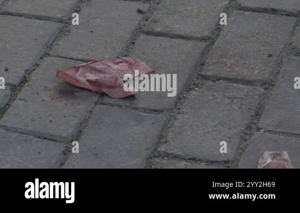 Bloodied napkins rest on cobblestones at a crime scene, providing ...