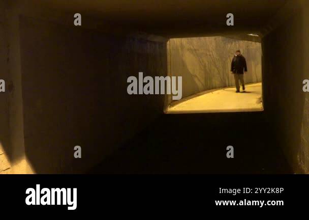 Riga, Latvia A man walks in an underground pedestrian tunnel at night ...