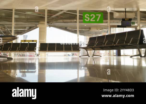 The airport terminal has a spacious, bright seating area near Gate S27 ...