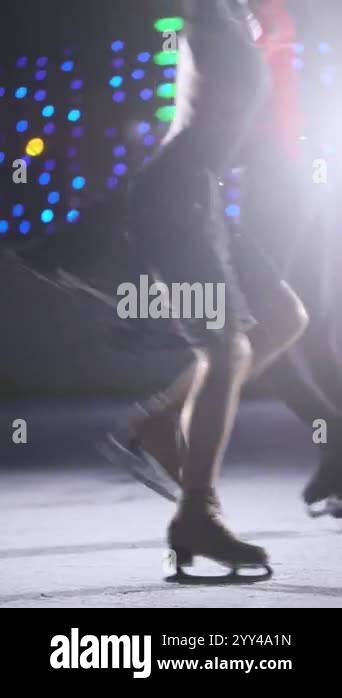 Vertical video, figure skating motion blur, young couple performs a dramatic dance on ice ...