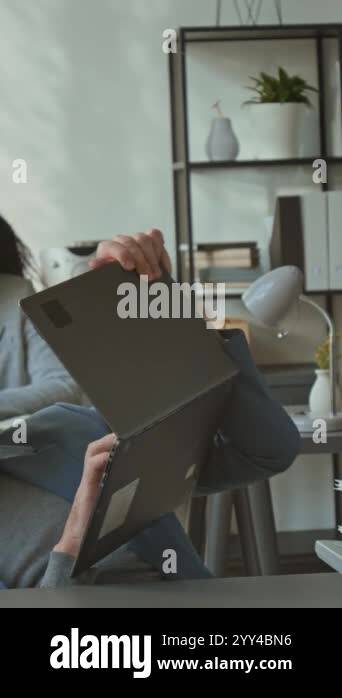 Vertical shot of hilarious office worker in clown wig and nose typing ...