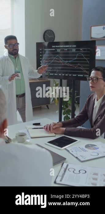 Vertical shot of doctor presenting statistical trends and data charts ...