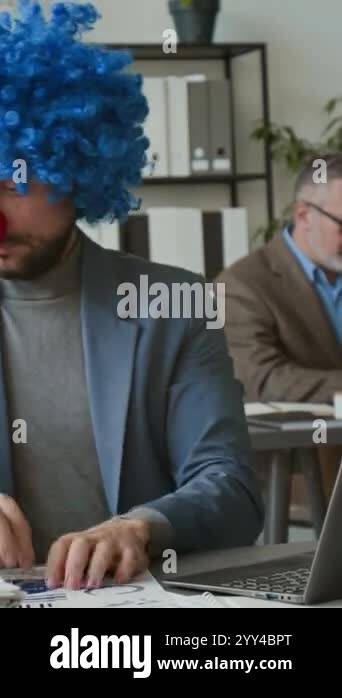 Vertical shot of hilarious businessman in clown wig and nose falling ...